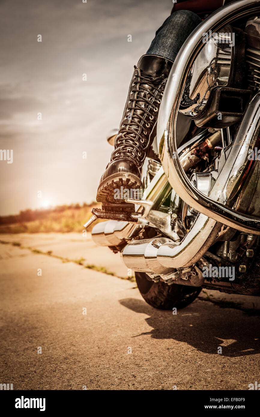Biker girl riding on a motorcycle. Bottom view of the legs in leather ...