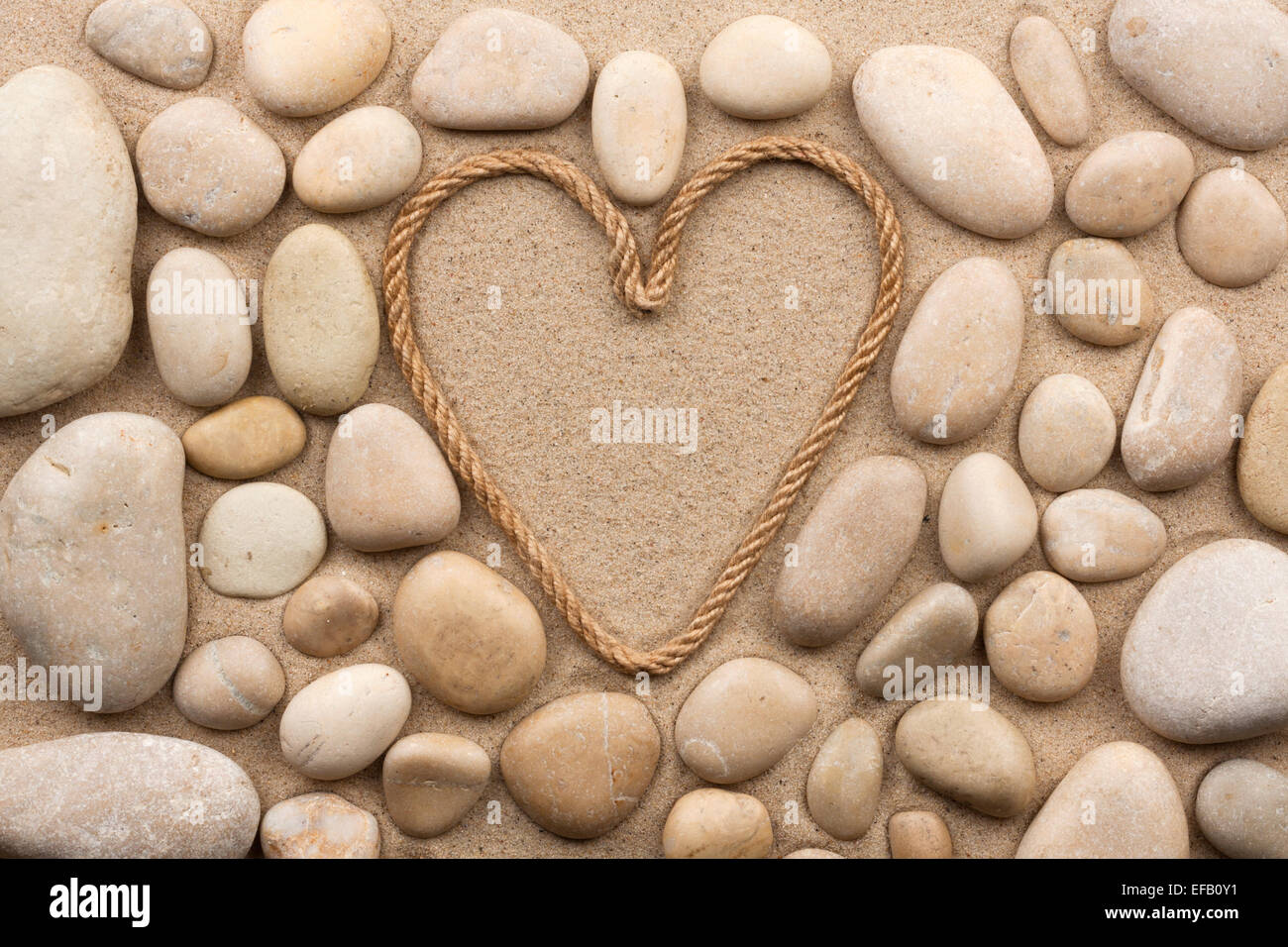 White heart stone on sand hi-res stock photography and images - Alamy