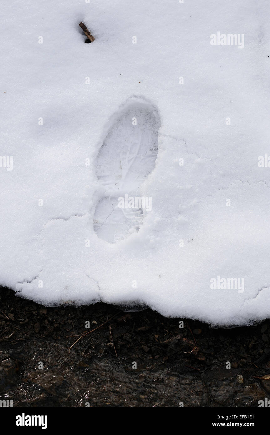 Shoe print in snow crossing creek Stock Photo - Alamy