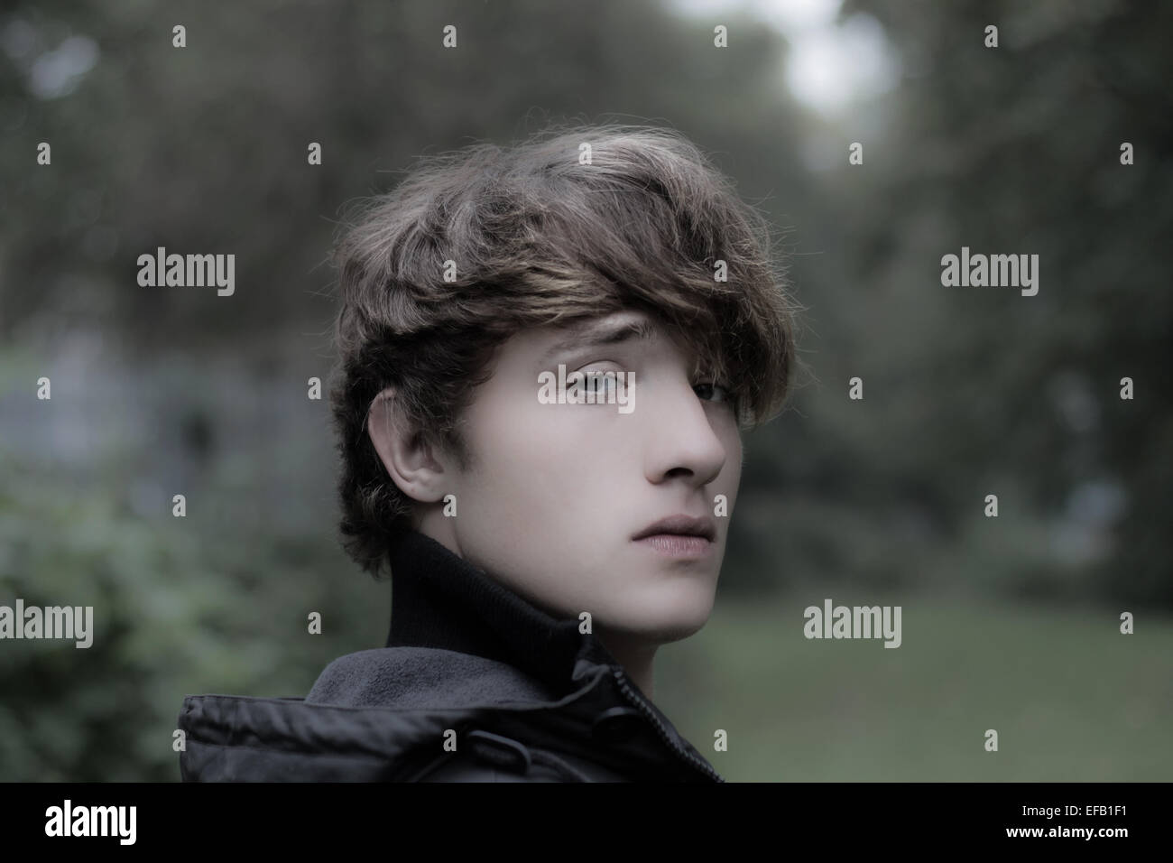 young man looking at camera over shoulder Stock Photo - Alamy