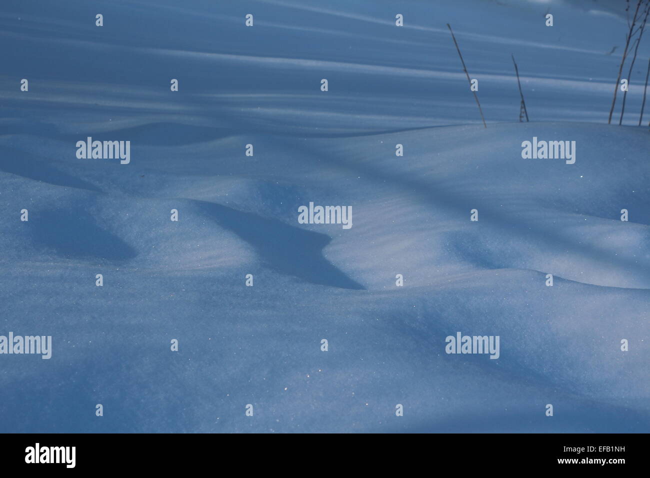 the sun is rising on a cold winder day , portraying snow drifts with ...