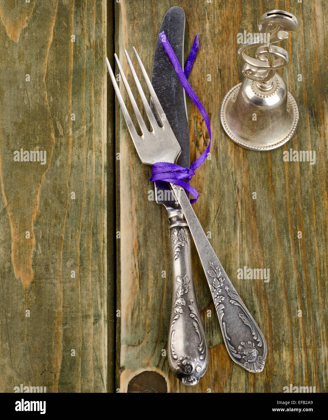Fork and knife on a wooden table Stock Photo - Alamy