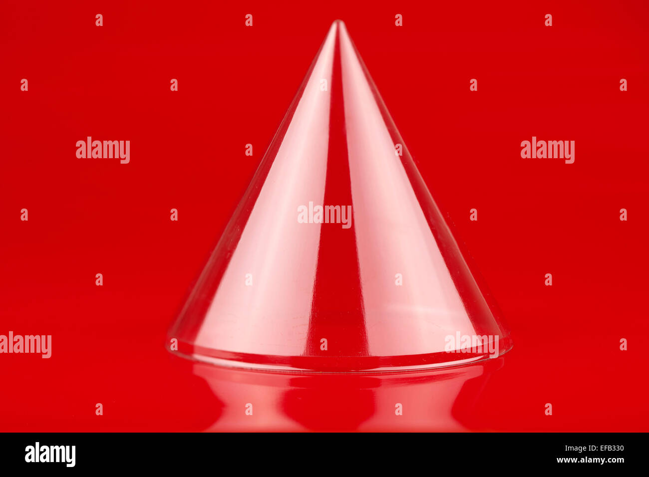 Clear plastic cone on a red background Stock Photo - Alamy