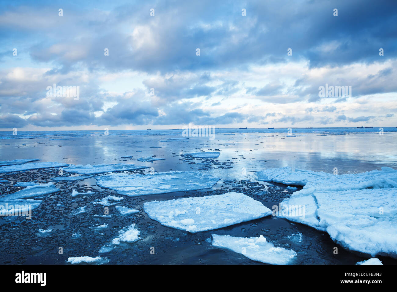 Winter coastal landscape with floating ice on deep blue sea water. Gulf ...