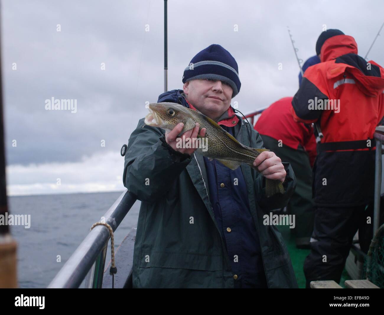 man with big cod fish on sea background Stock Photo - Alamy