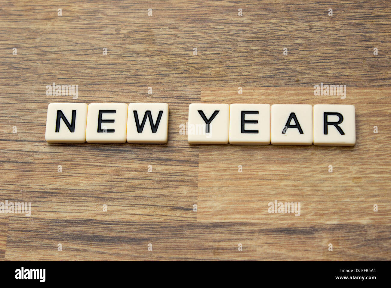 The word new year written in tiles on a wooden surface Stock Photo - Alamy