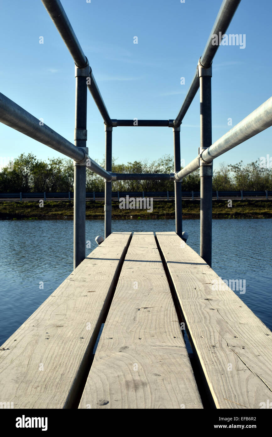 perspective view of a small pier over fresh water canal Stock Photo - Alamy