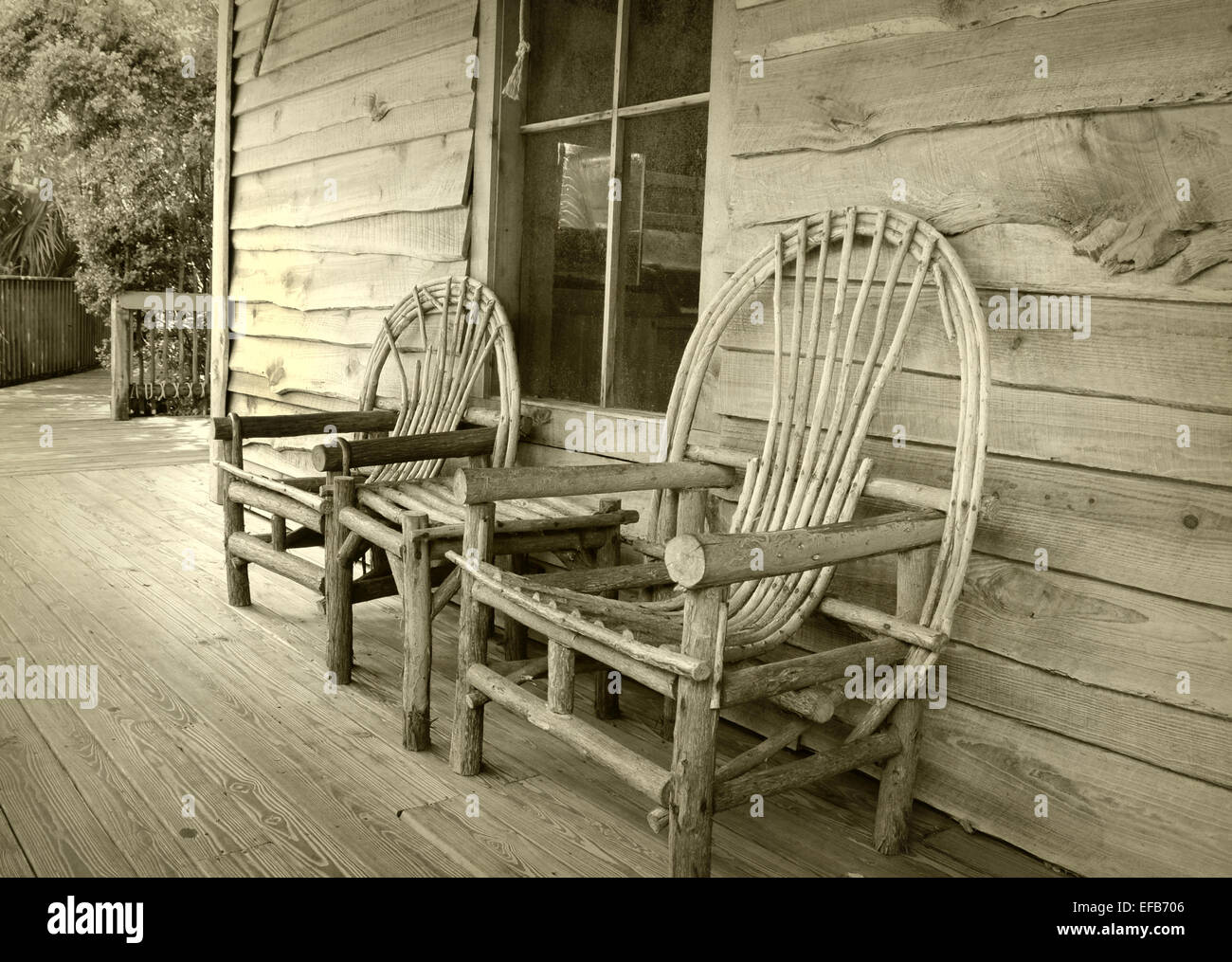 Old fashioned frontier home with porch and chairs Stock Photo - Alamy