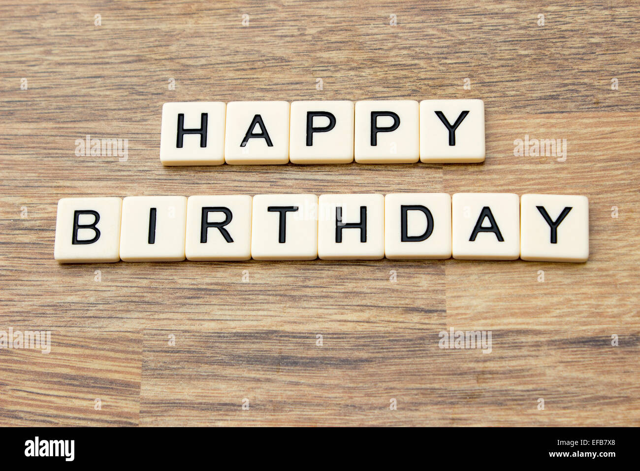 The word happy birthday written in tiles on a wooden surface Stock ...