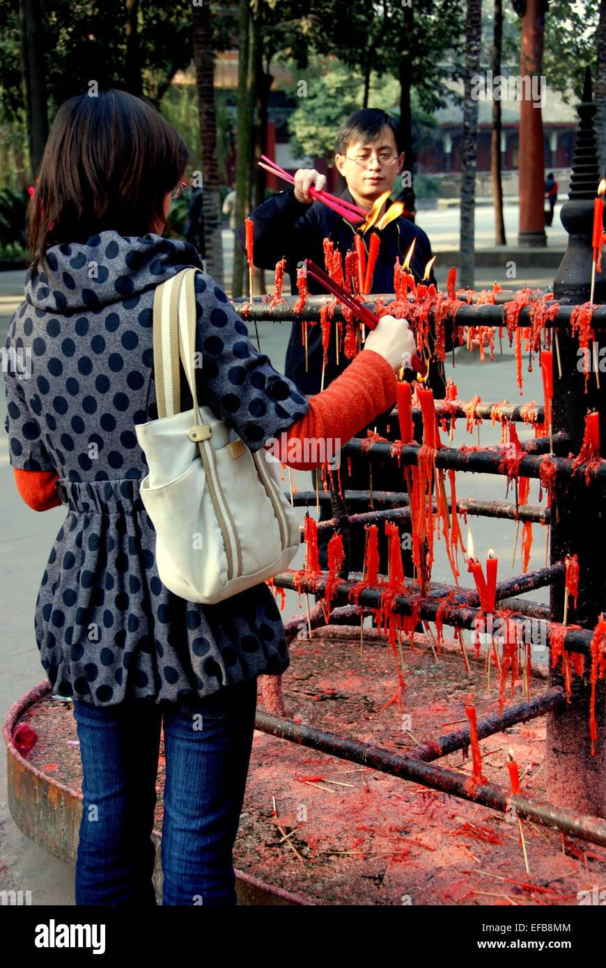 Chengdu, China: People lighting red candles in a courtyard at the ...