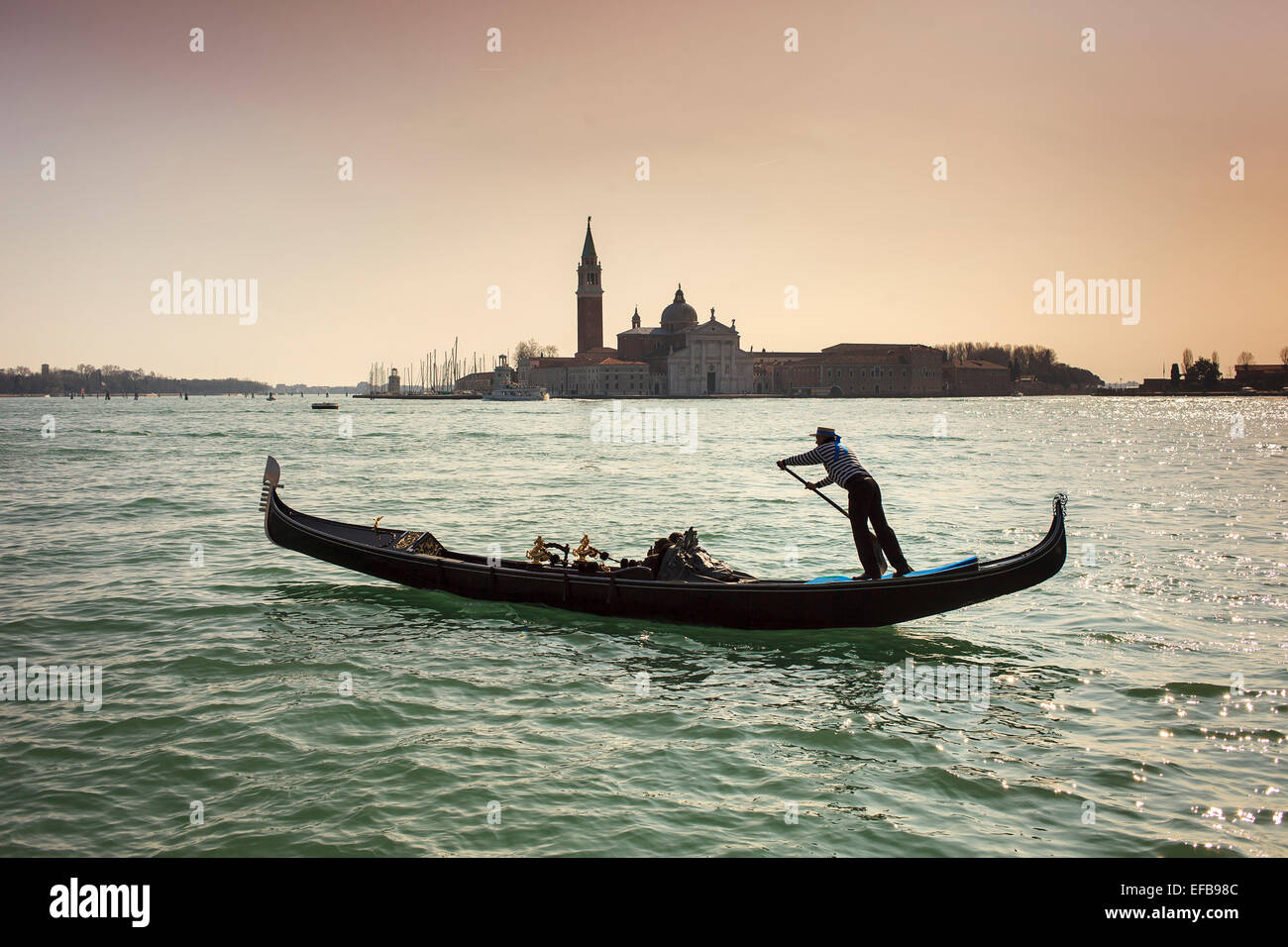 Il veneziano, Gondolier and his gondola transporting tourists through ...
