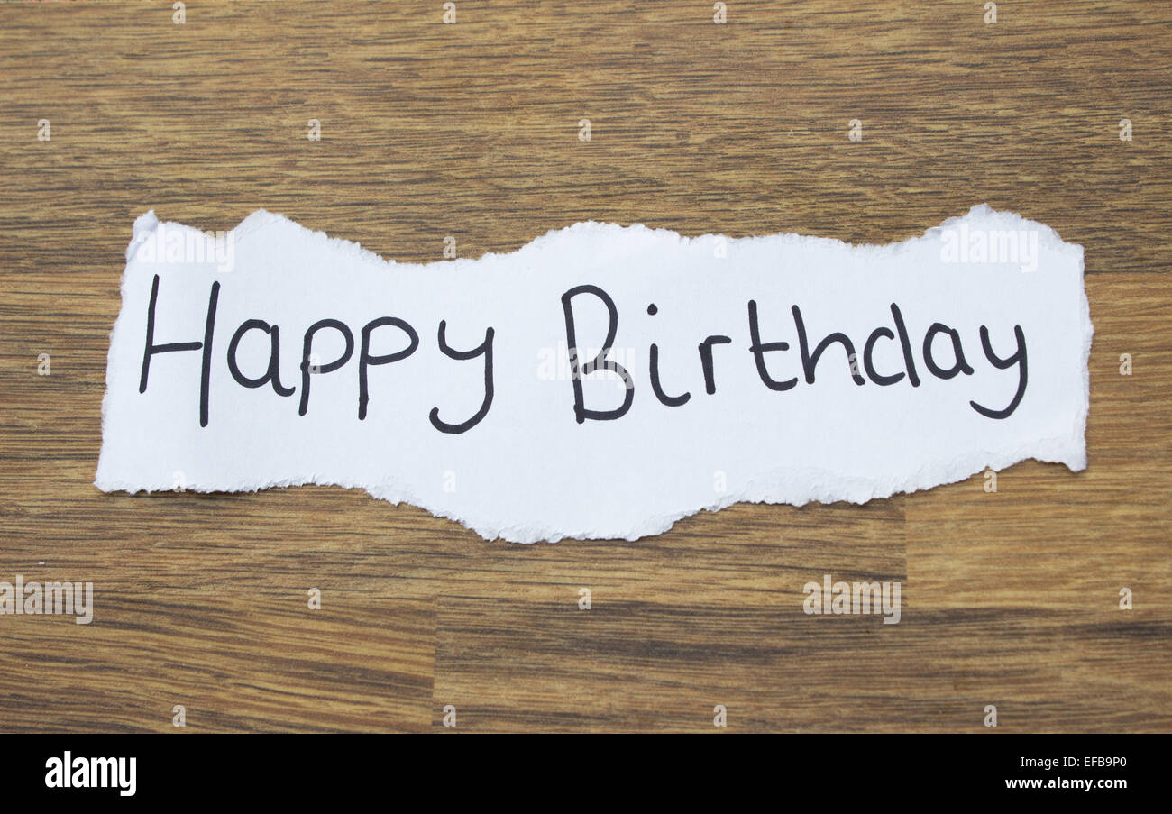 Happy Birthday written on torn paper, placed on wooden background Stock ...