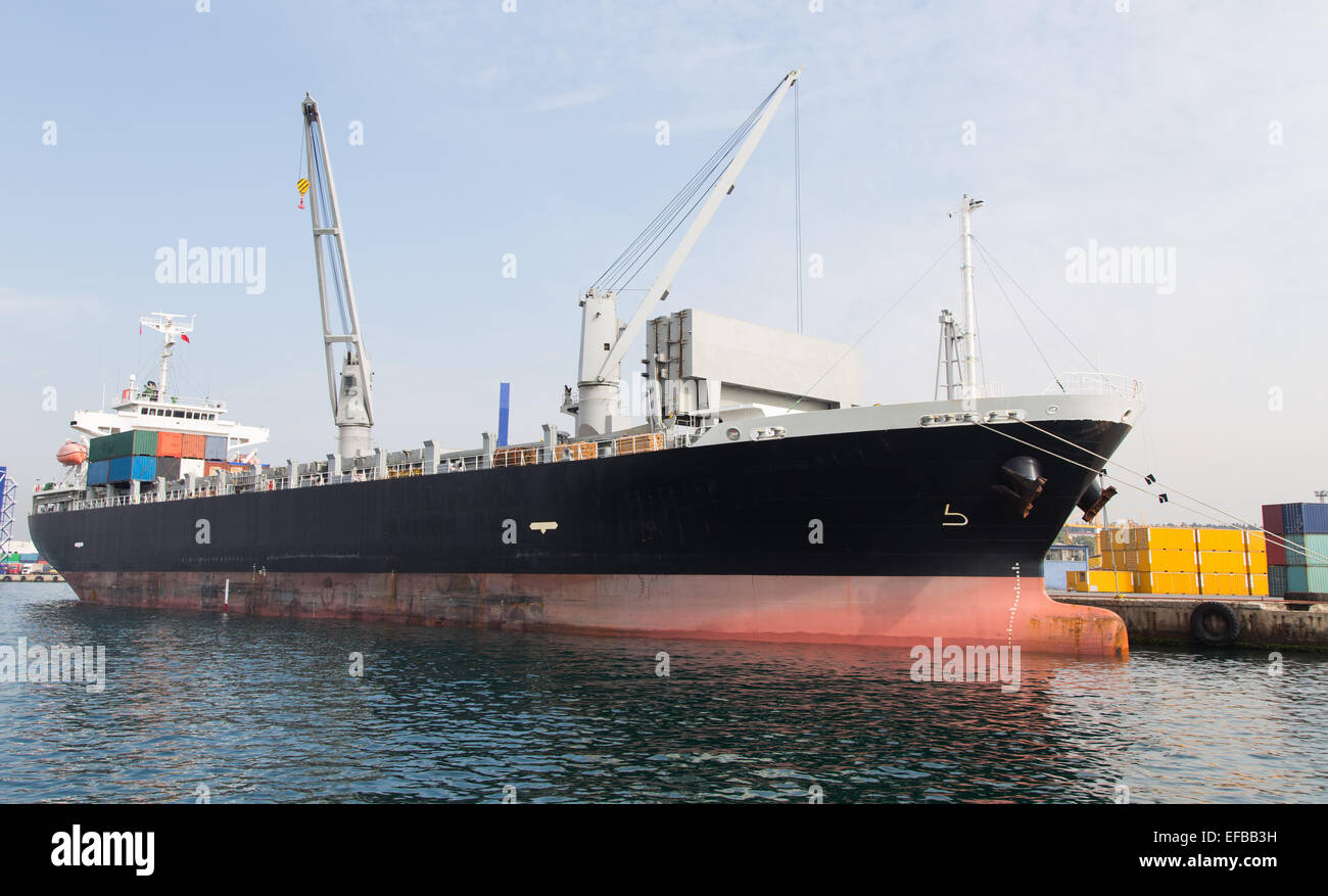 Cargo ship loading in a trading port Stock Photo - Alamy