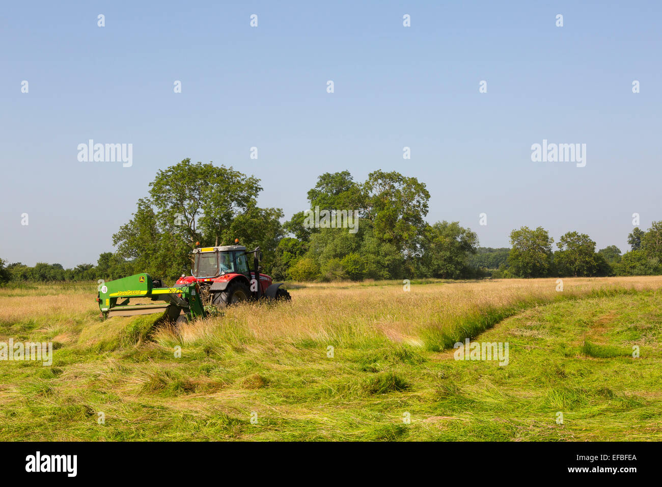 Tractor and hay mower mowing field, Oxfordshire, England Stock Photo ...