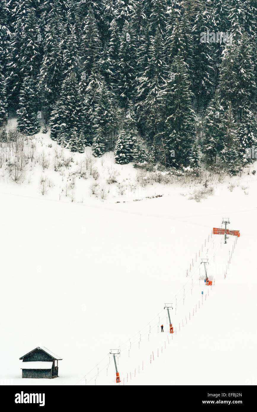 Platter ski lift at beginners piste pulling a skier up the flat slope ...