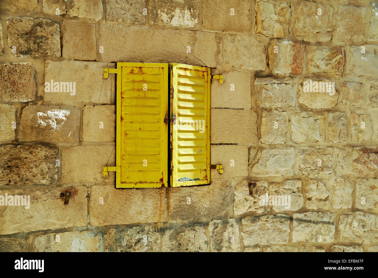 Old yellow shutters on the stone wall Stock Photo - Alamy