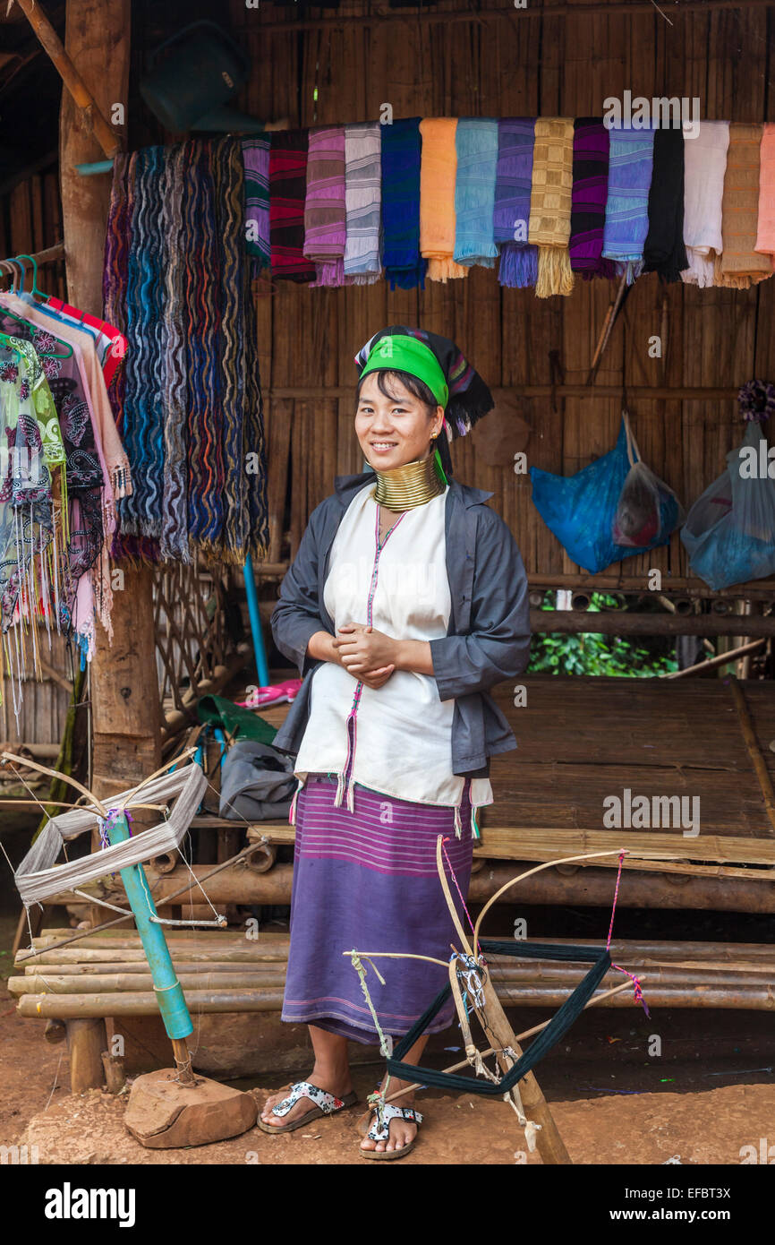 Young Burmese long neck woman standing outside a fabric souvenir shop ...