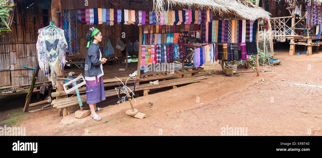 Young Burmese long neck woman standing outside a fabric souvenir shop ...