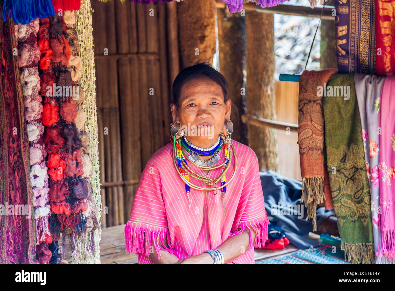 Woman with traditional pierced ear lobes and necklaces at a souvenir ...