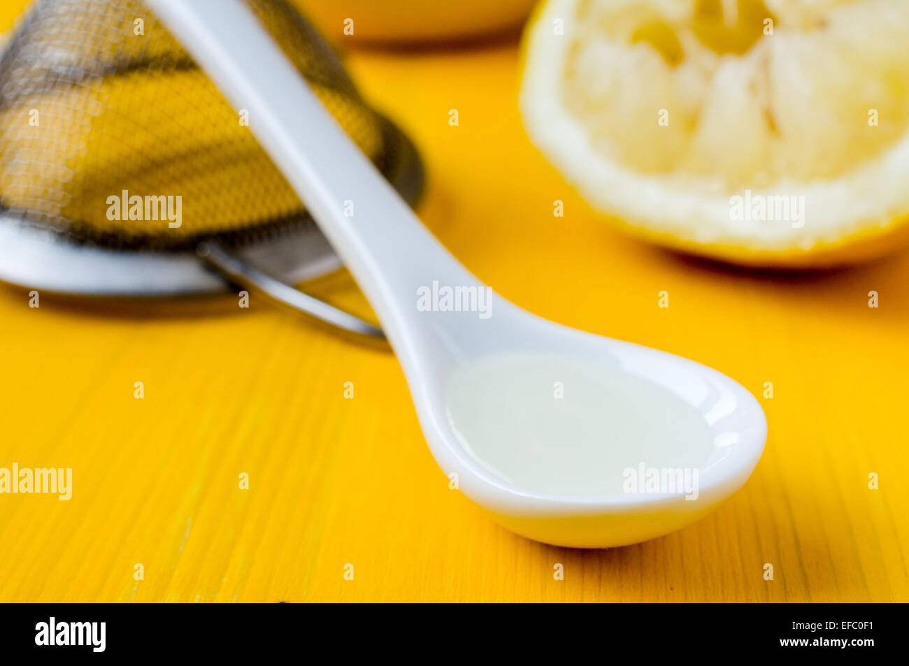 Lemon juice in the spoon near squeezed lemon Stock Photo - Alamy