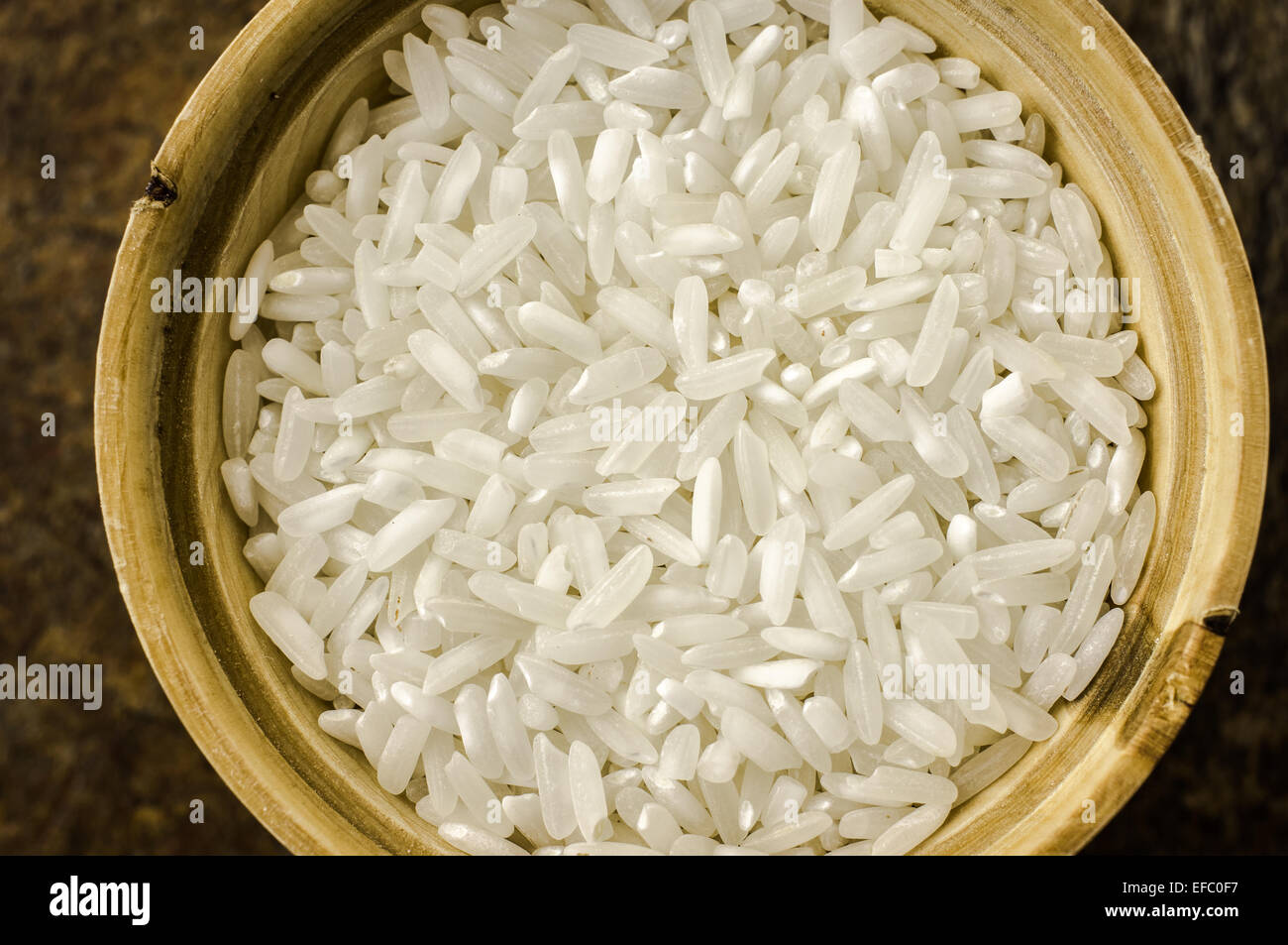 Long grain rice in a wooden bowl, top view Stock Photo - Alamy