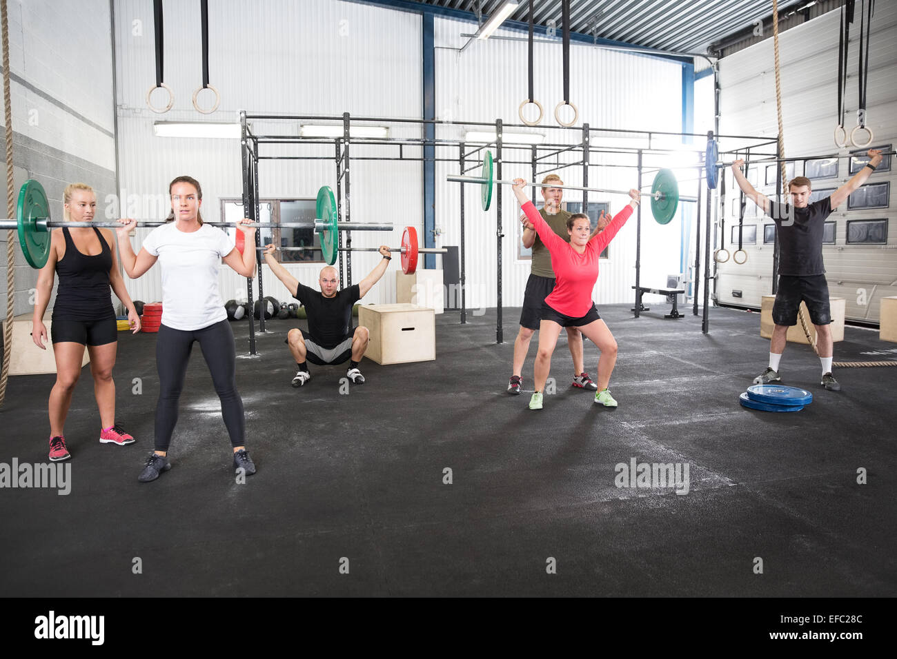 Team workout with weights at fitness gym center Stock Photo - Alamy