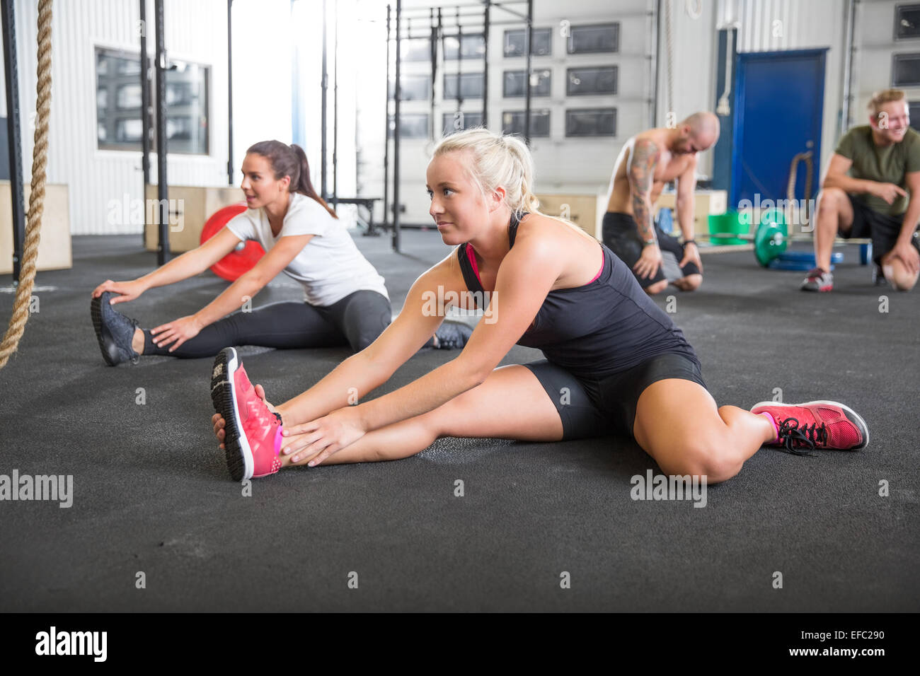 Two women stretching on the floor Stock Photo - Alamy
