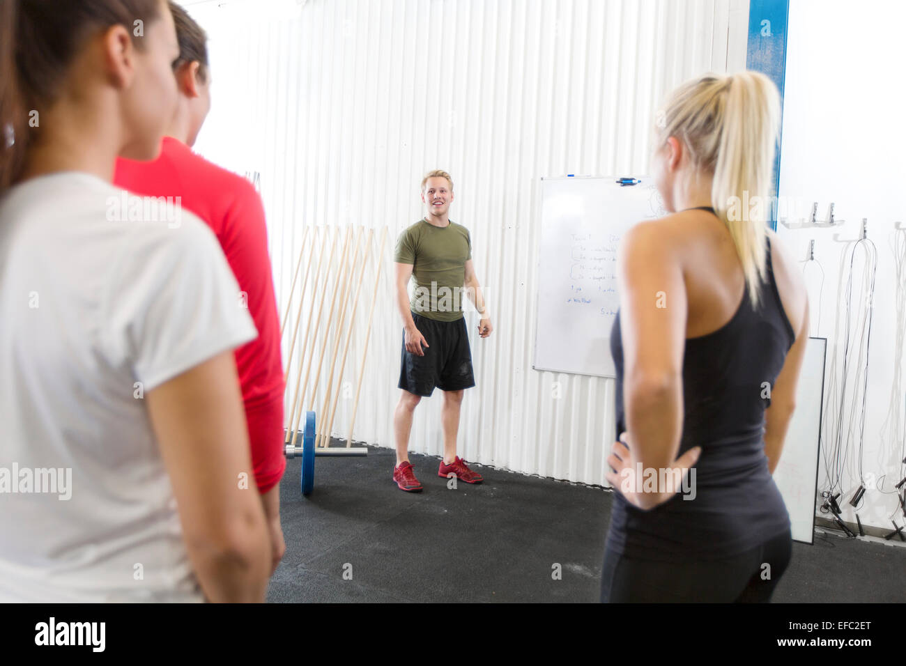 Personal trainer instructs fitness workout team Stock Photo - Alamy