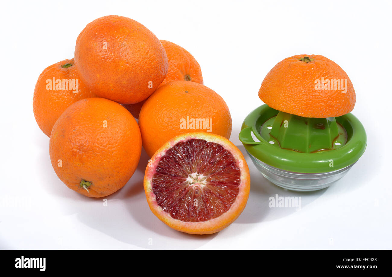 pressing a blood orange isolated on a white background Stock Photo - Alamy