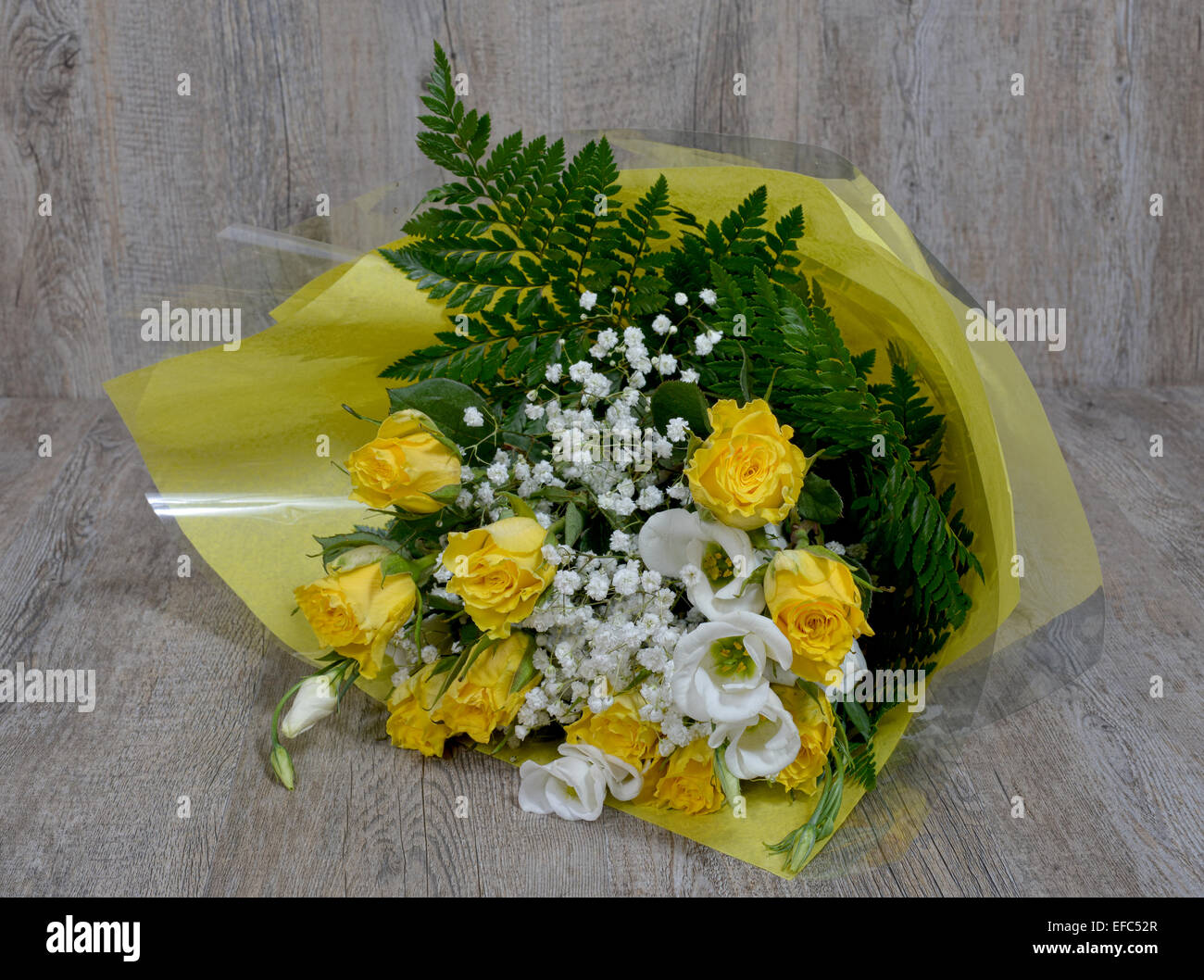 bouquet of yellow roses placed on a wooden table Stock Photo - Alamy