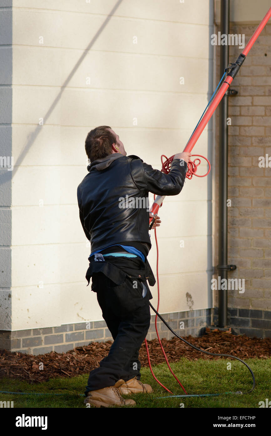 Window cleaner - cleaning first floor windows with extending brush in ...
