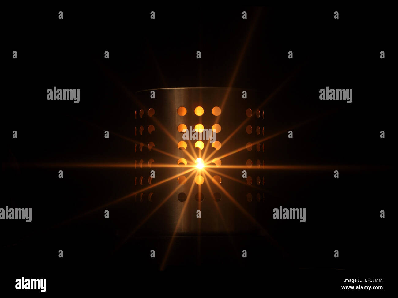 Conceptual background image of a perforated metal cylindrical container ...