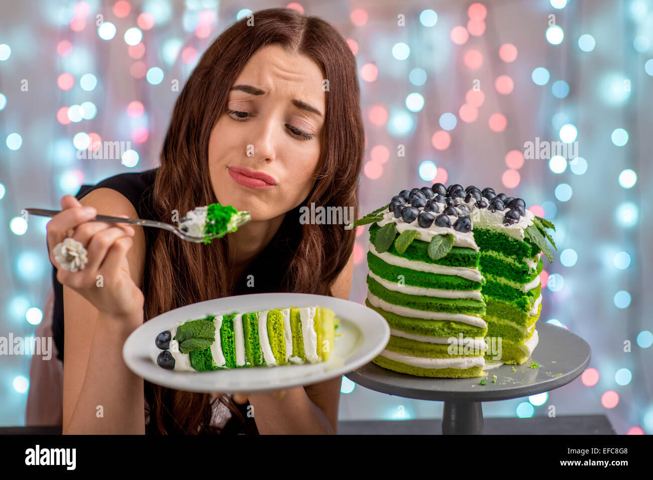 Sad girl thinking eat or not to eat happy birthday cake sitting on ...