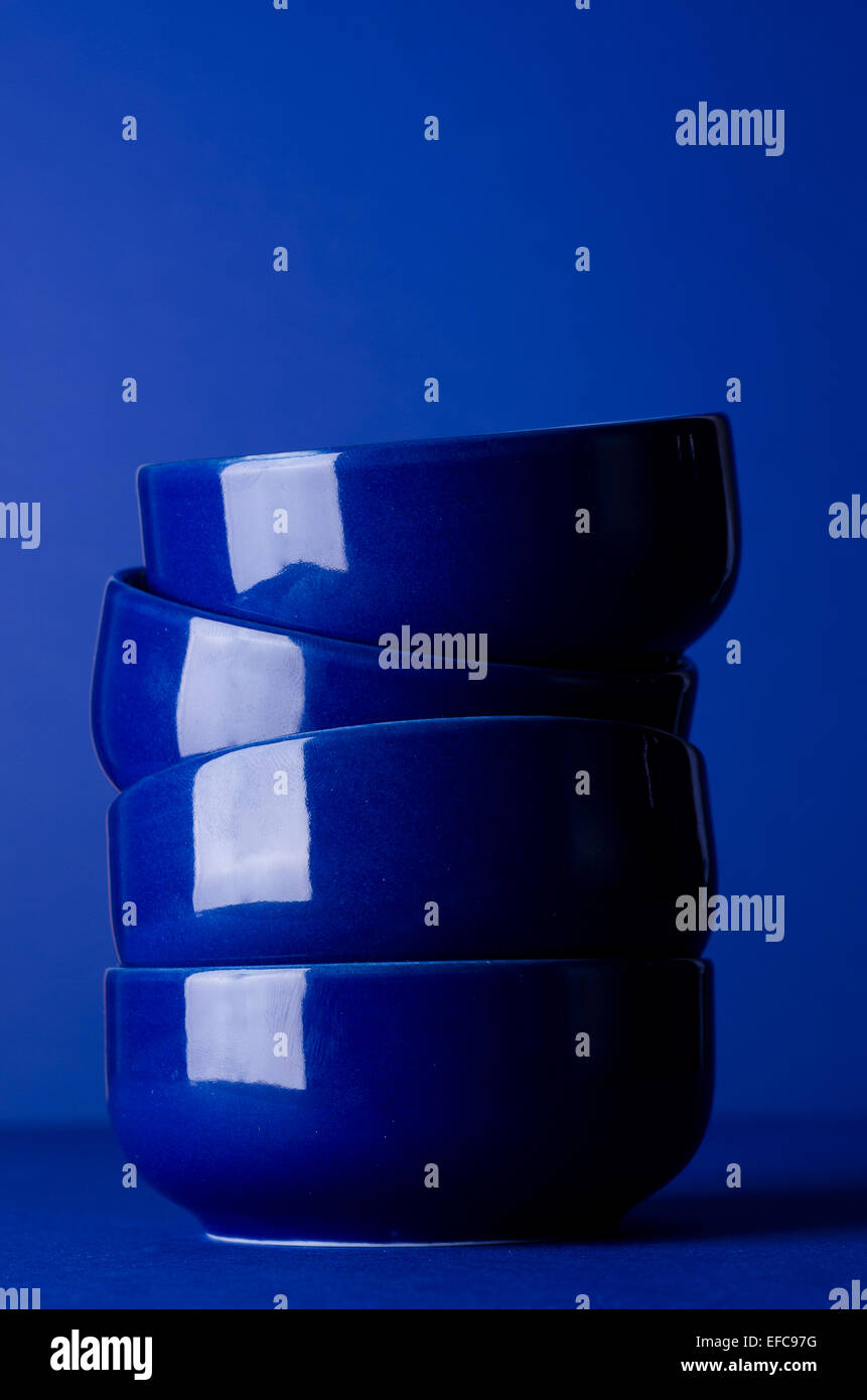 Stack of blue bowls over dark blue background Stock Photo - Alamy