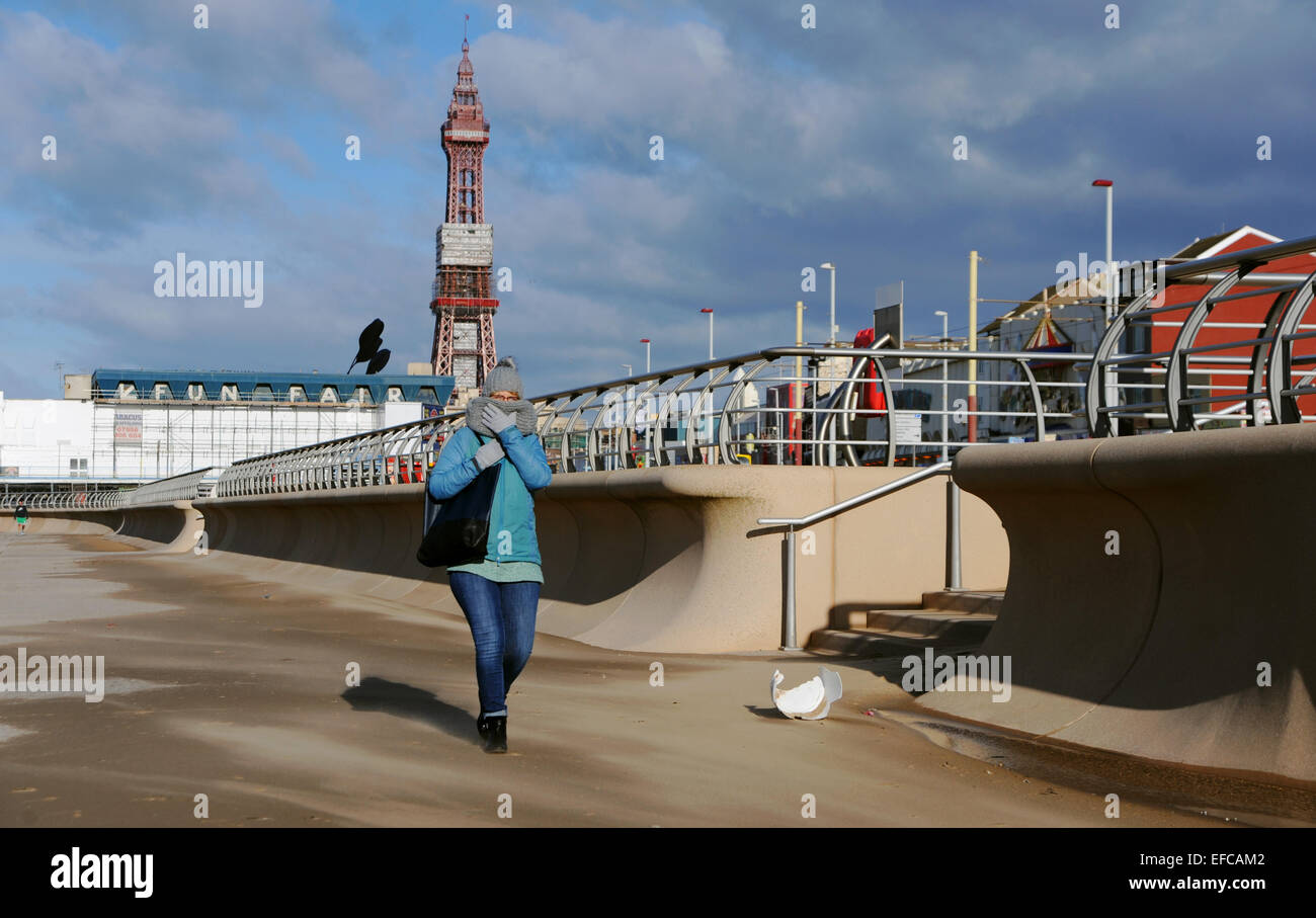 A woman wrapped against the cold walks along Blackpool seafront as the ...