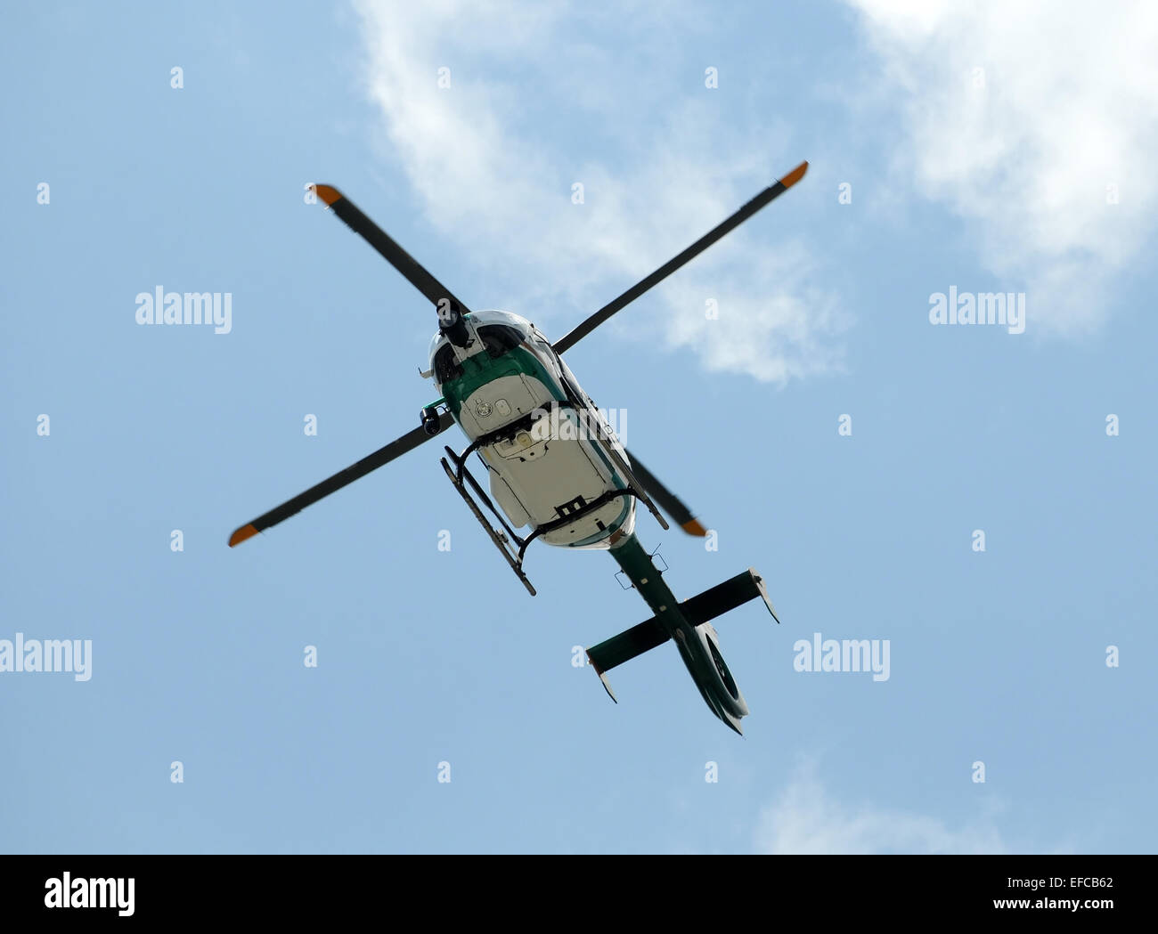 Modern helicopter flying overhead on blue sky Stock Photo - Alamy