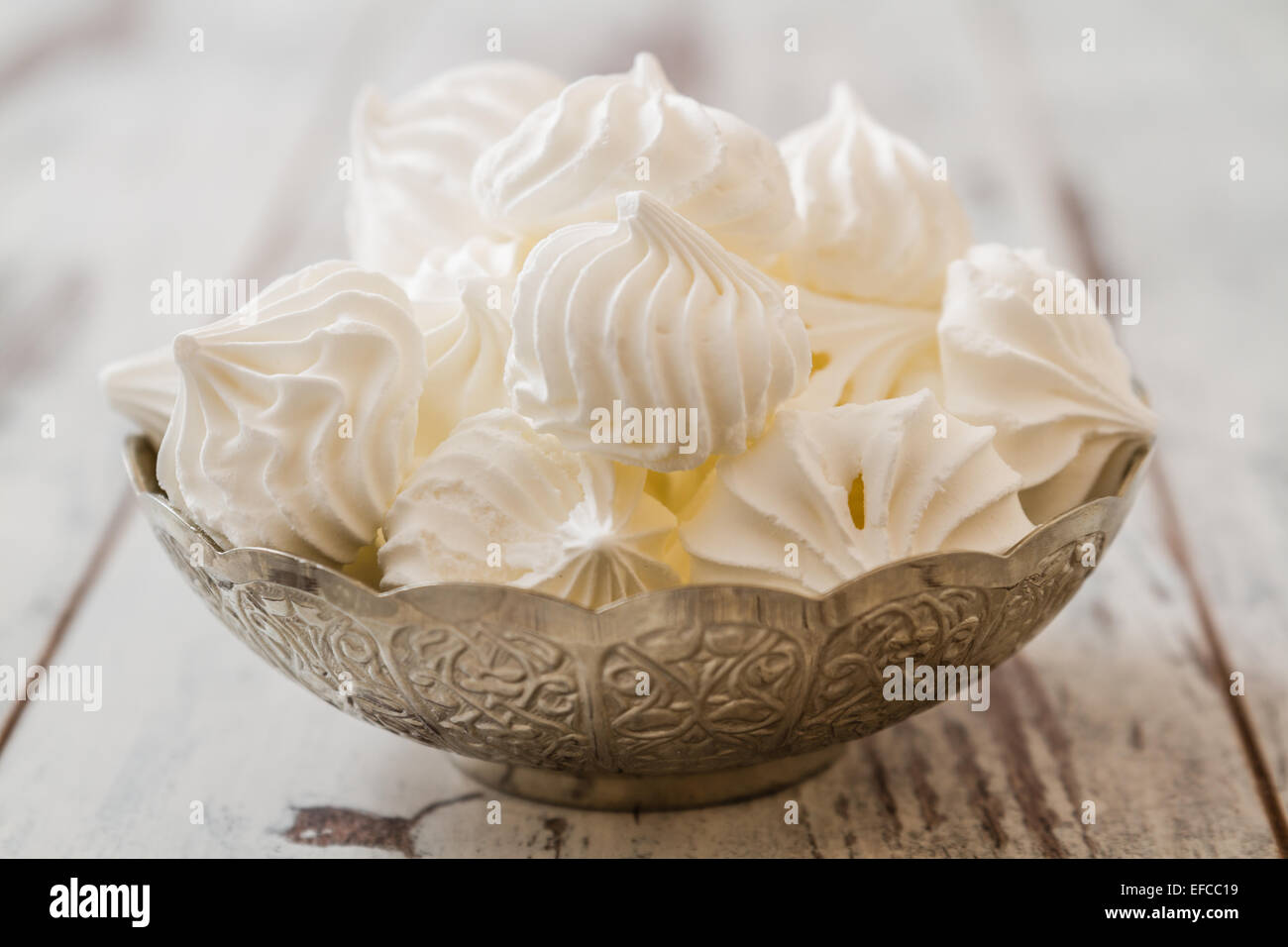Delicious and plain white vanilla meringue cookies in silver ...