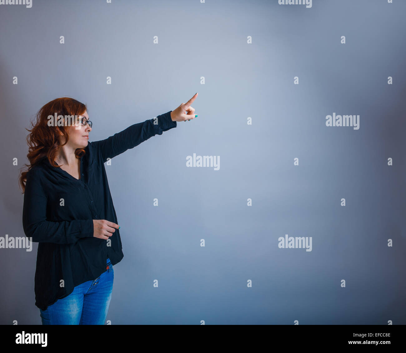 European - looking woman of 30 years is pointing in the direction of ...