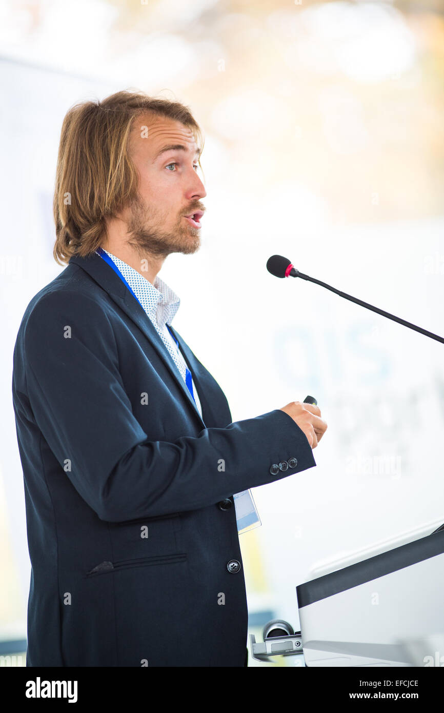 Handsome young man giving a speech at a conference Stock Photo - Alamy
