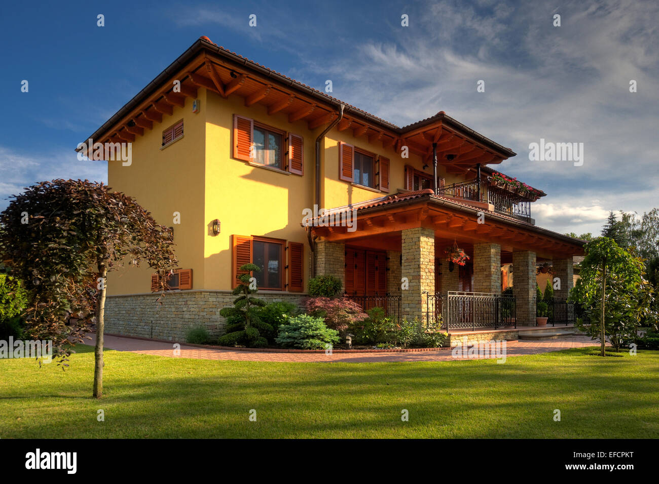 Big Family home with green grass and blue sky Stock Photo - Alamy