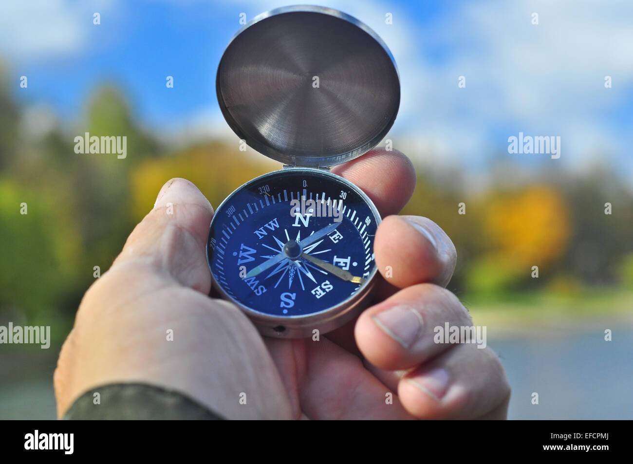 Compass and hand. The magnetic compass is in his hand on the autumn ...