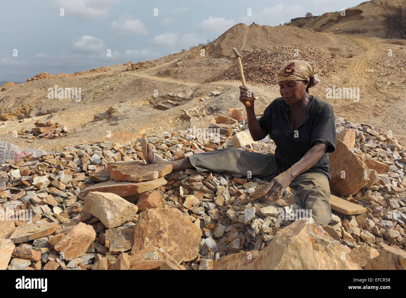 A woman works breaking rocks into gravel at a quarry near Accra, Ghana ...