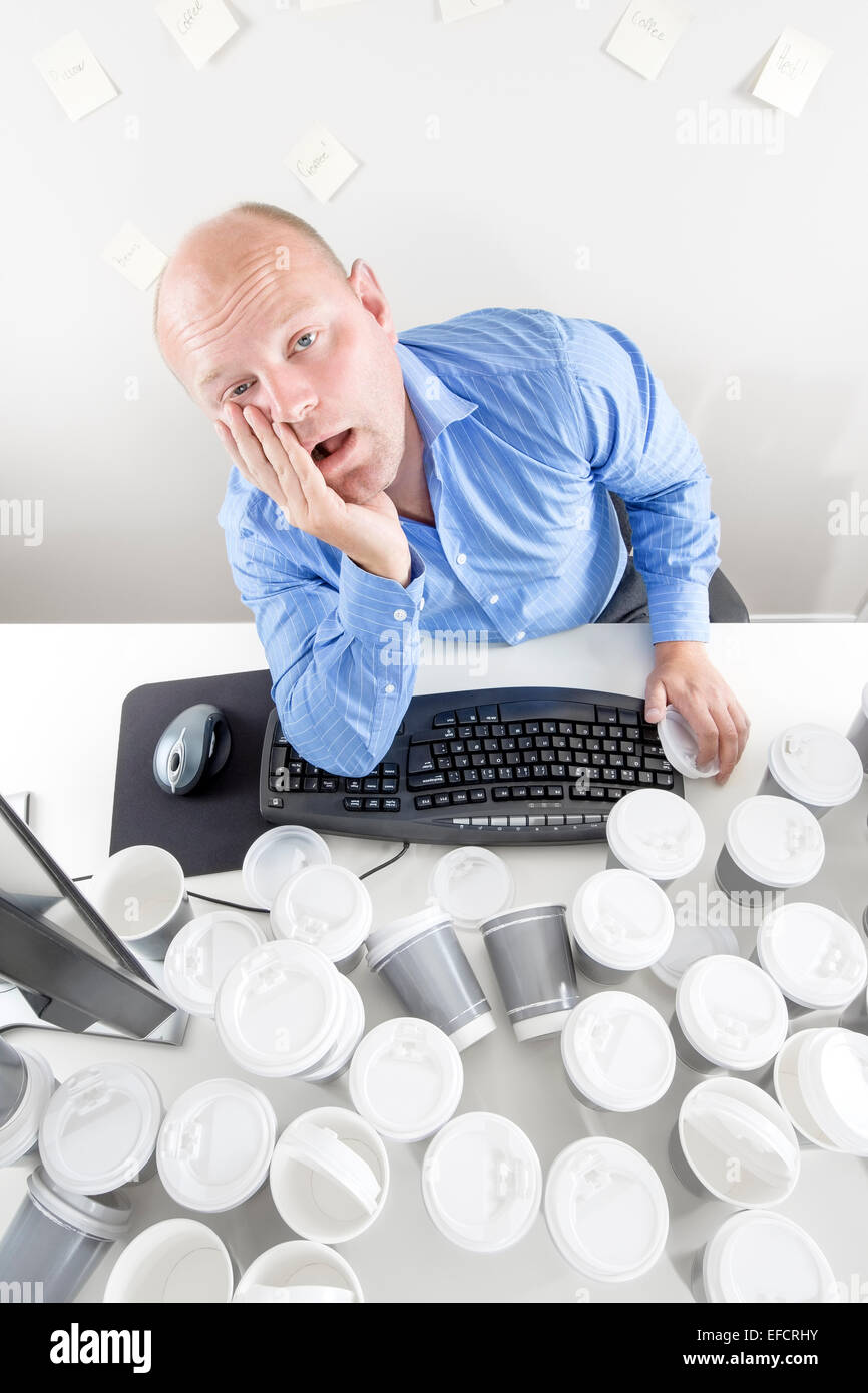 Overworked man at the office Stock Photo - Alamy