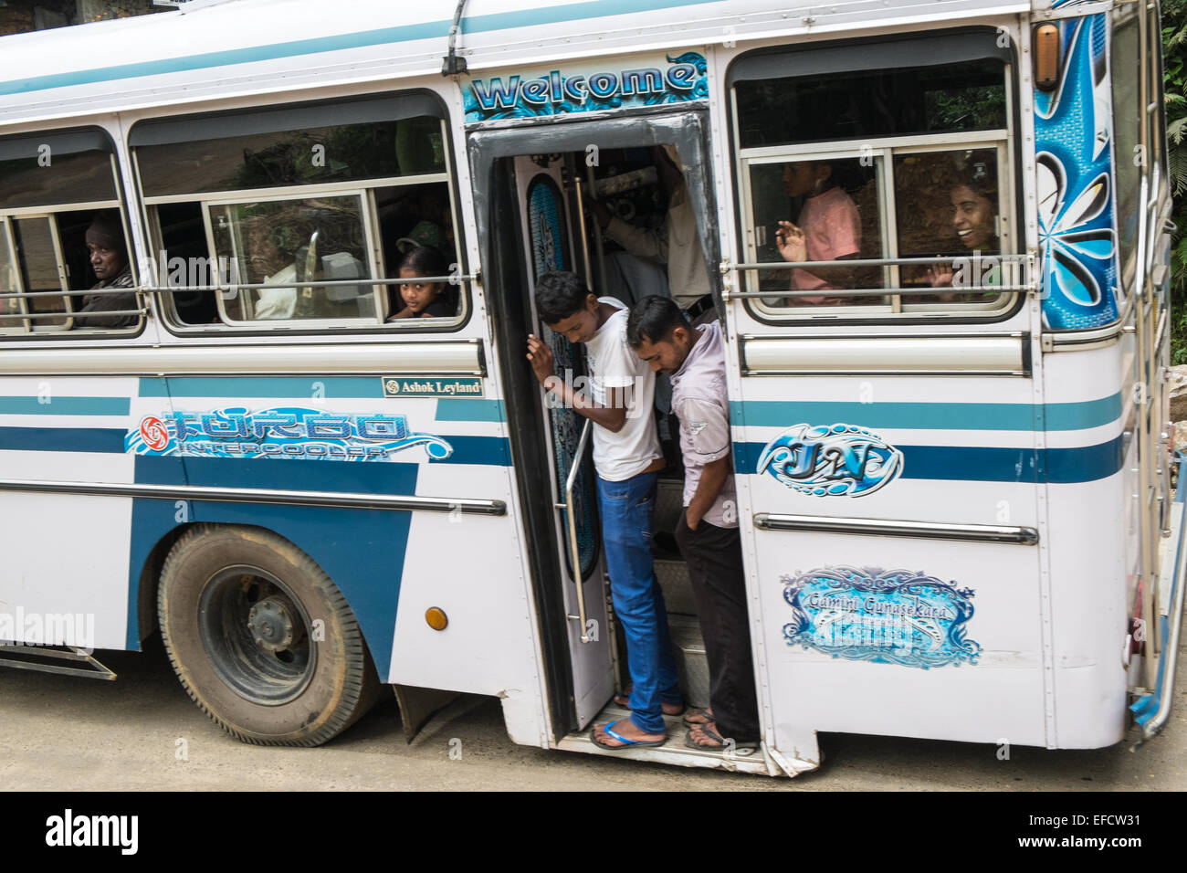 Crammed full local bus heavy load with little clearance scrapes along ...