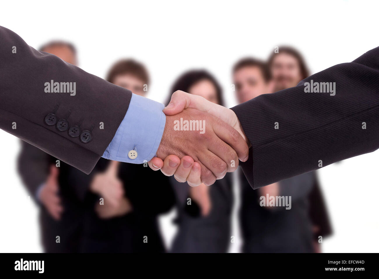 handshake, with business team in background Stock Photo - Alamy