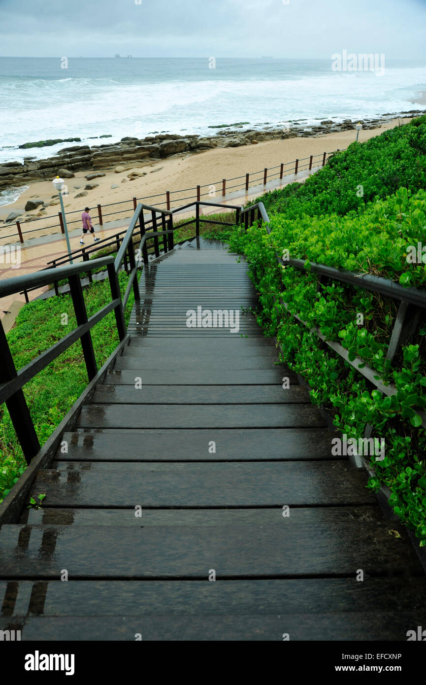 Wet wooden stairs leading to paved boardwalk at Umhlanga Rocks beach ...