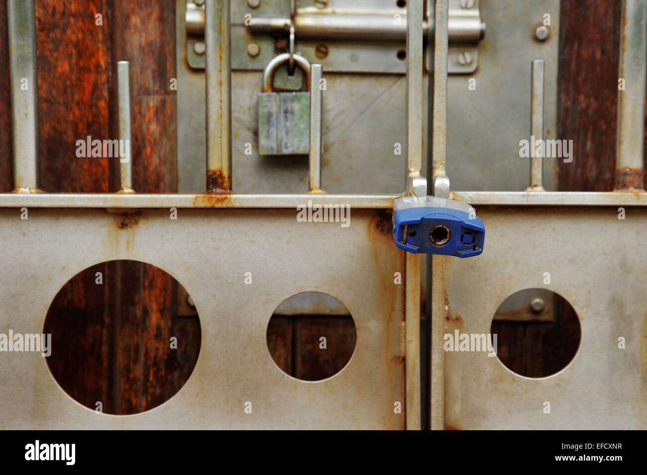 Rusting gate and door securely closed with two locks Still life ...