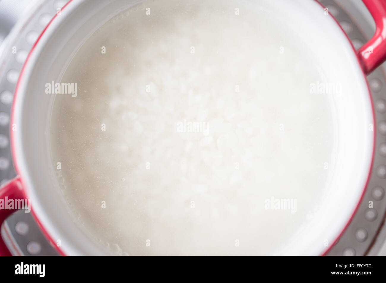 Rice in a saucepan on the stove to cook Stock Photo - Alamy