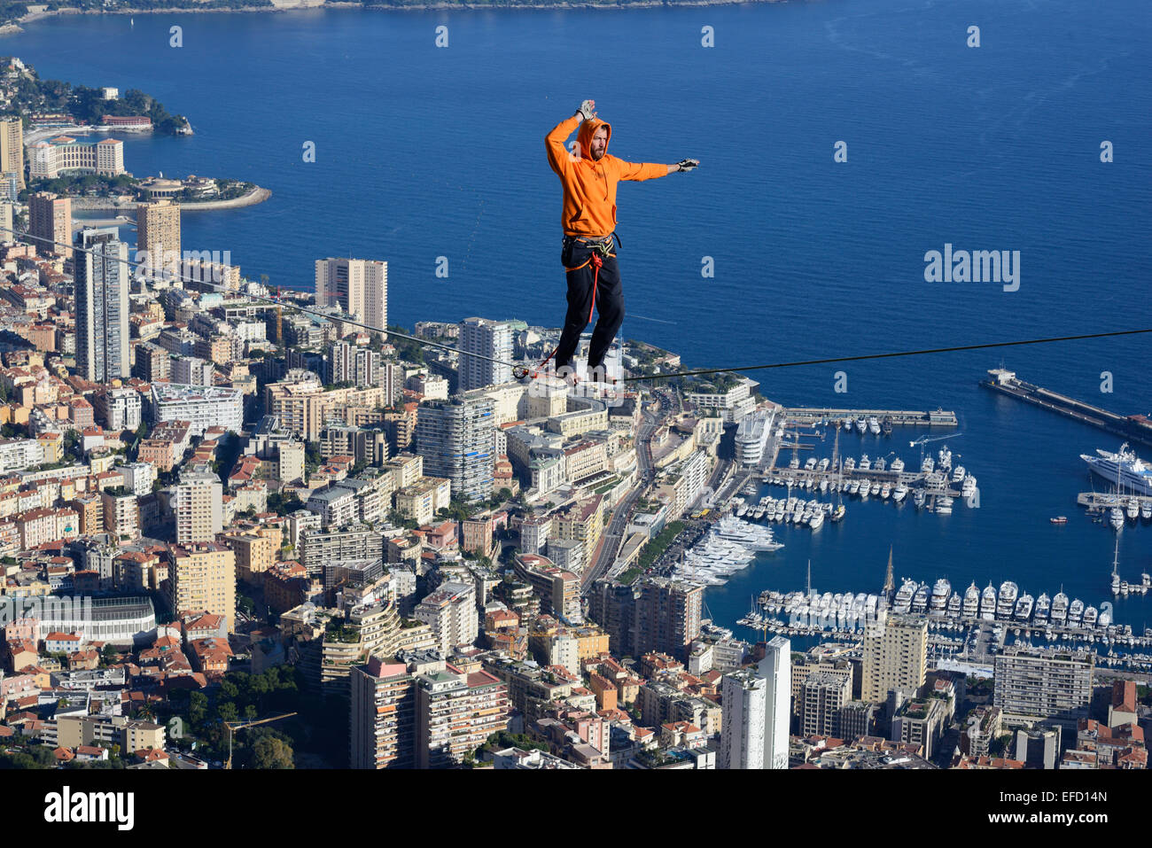 Young man highlining (slacklining) at an elevation of 550 meters Above ...