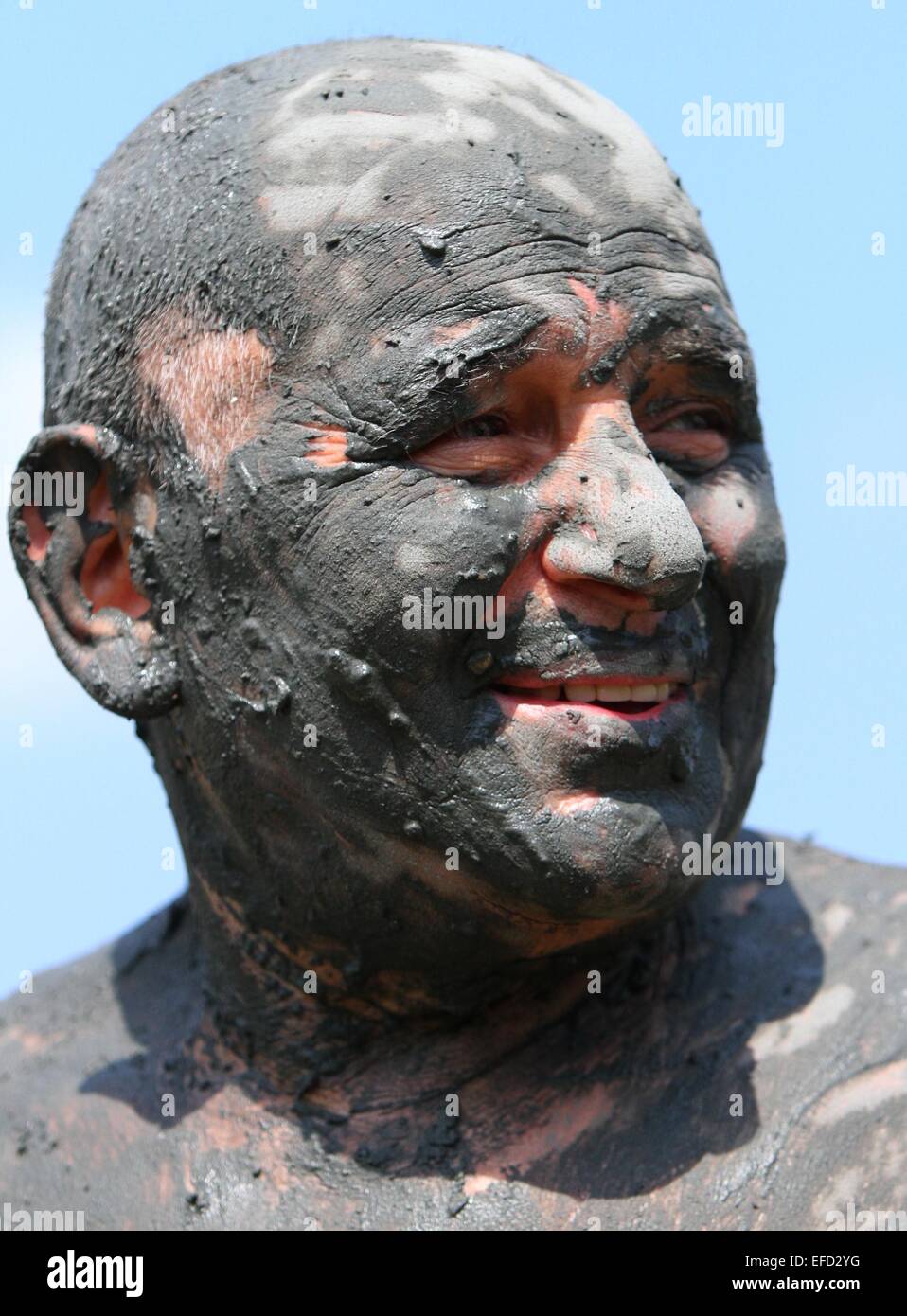 Visitors smear black mud over their bodies as they participate in the ...